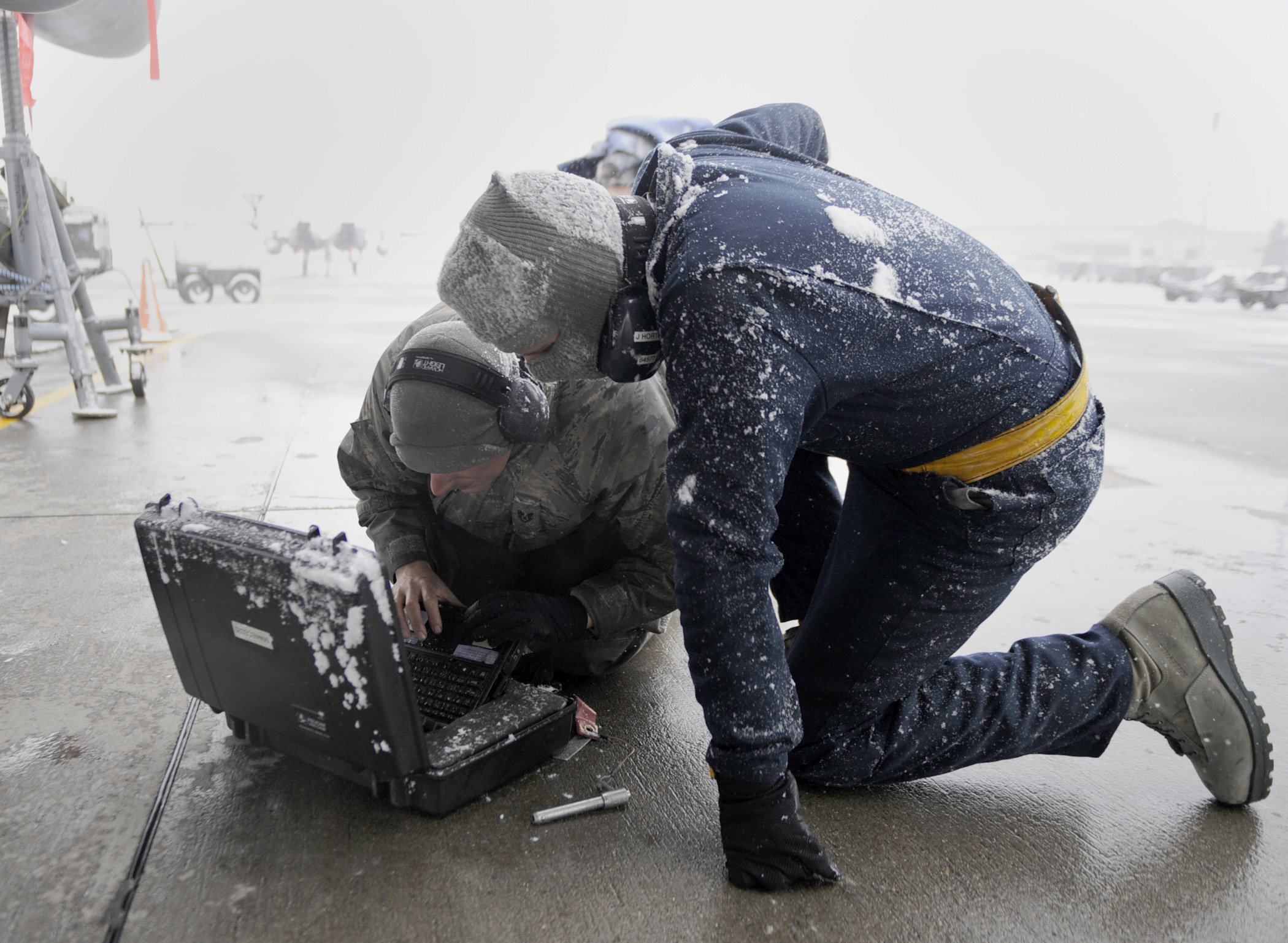 Airmen work under harsh weather conditions
