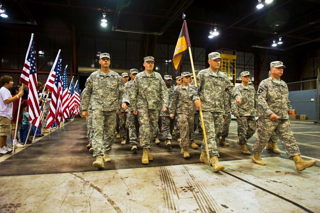 Family and friends hold American flags for soldiers as they march ...