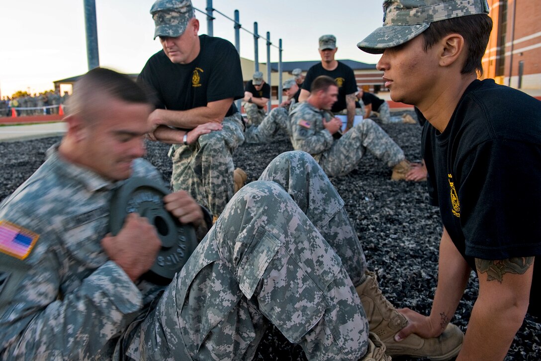 U.S. Army soldiers hold twenty-five pound weights to their chest while ...