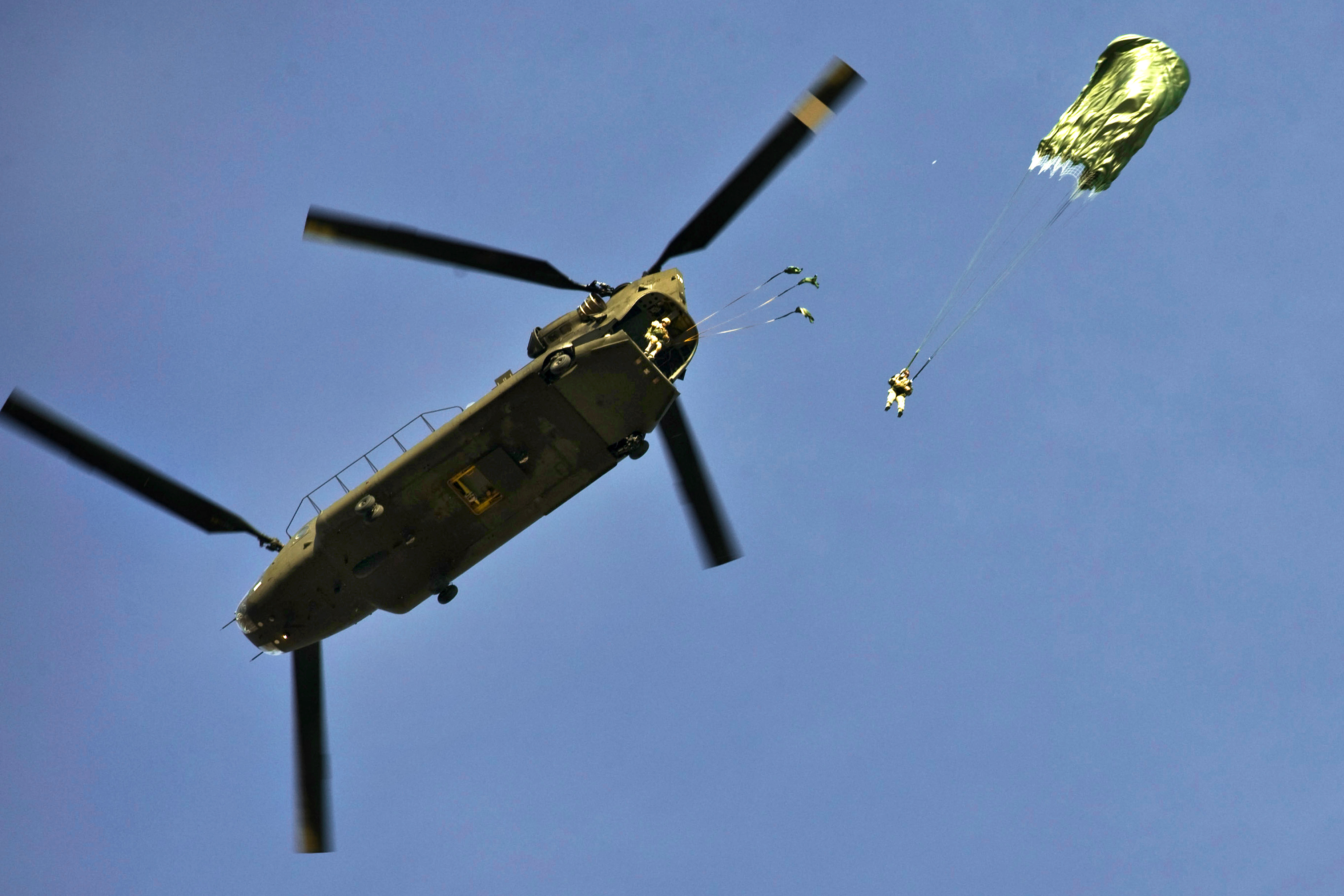 U.S. Air Force airmen jump from a U.S. Army CH-47 Chinook helicopter ...