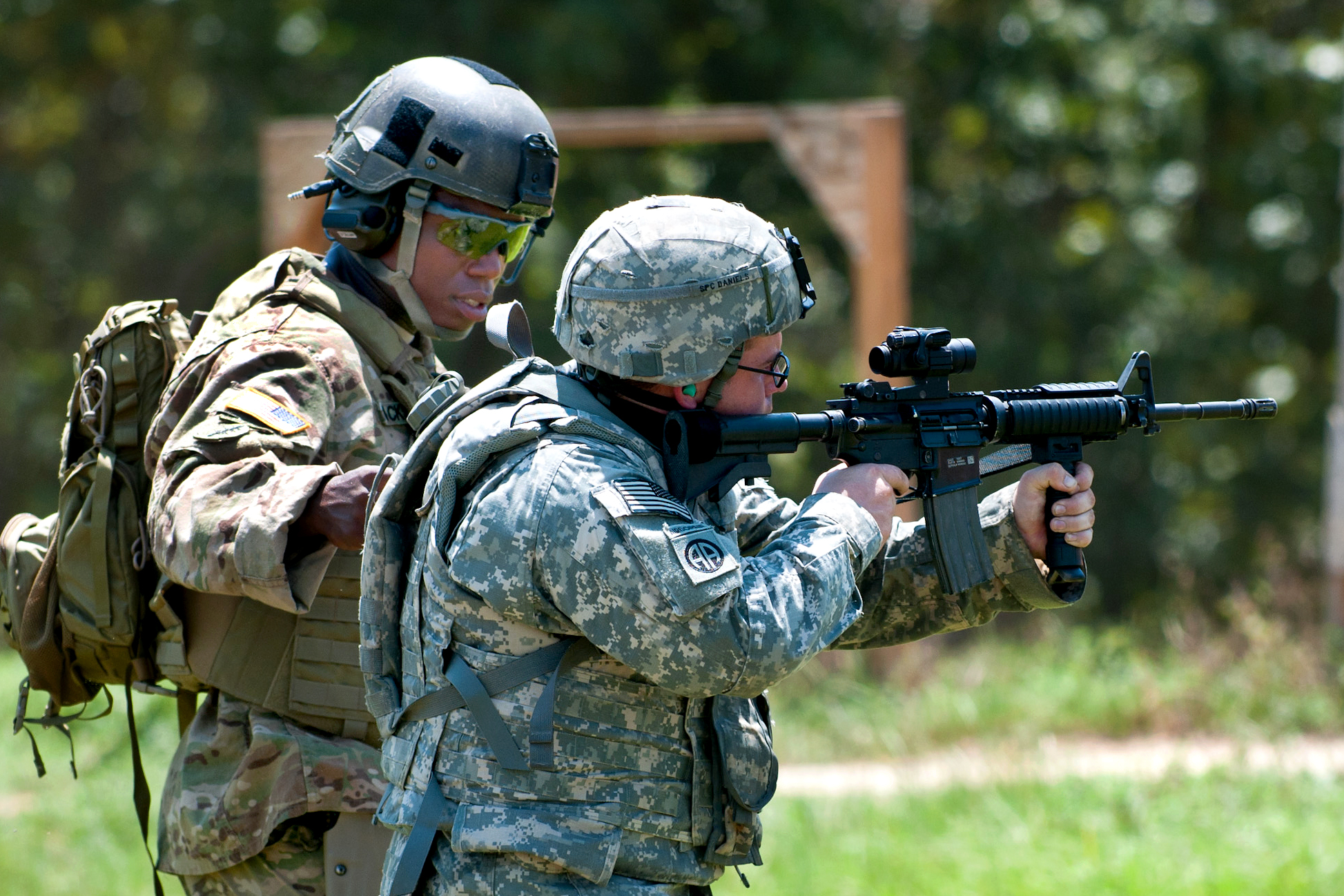 An Army instructor works with an Army paratrooper on close quarter ...