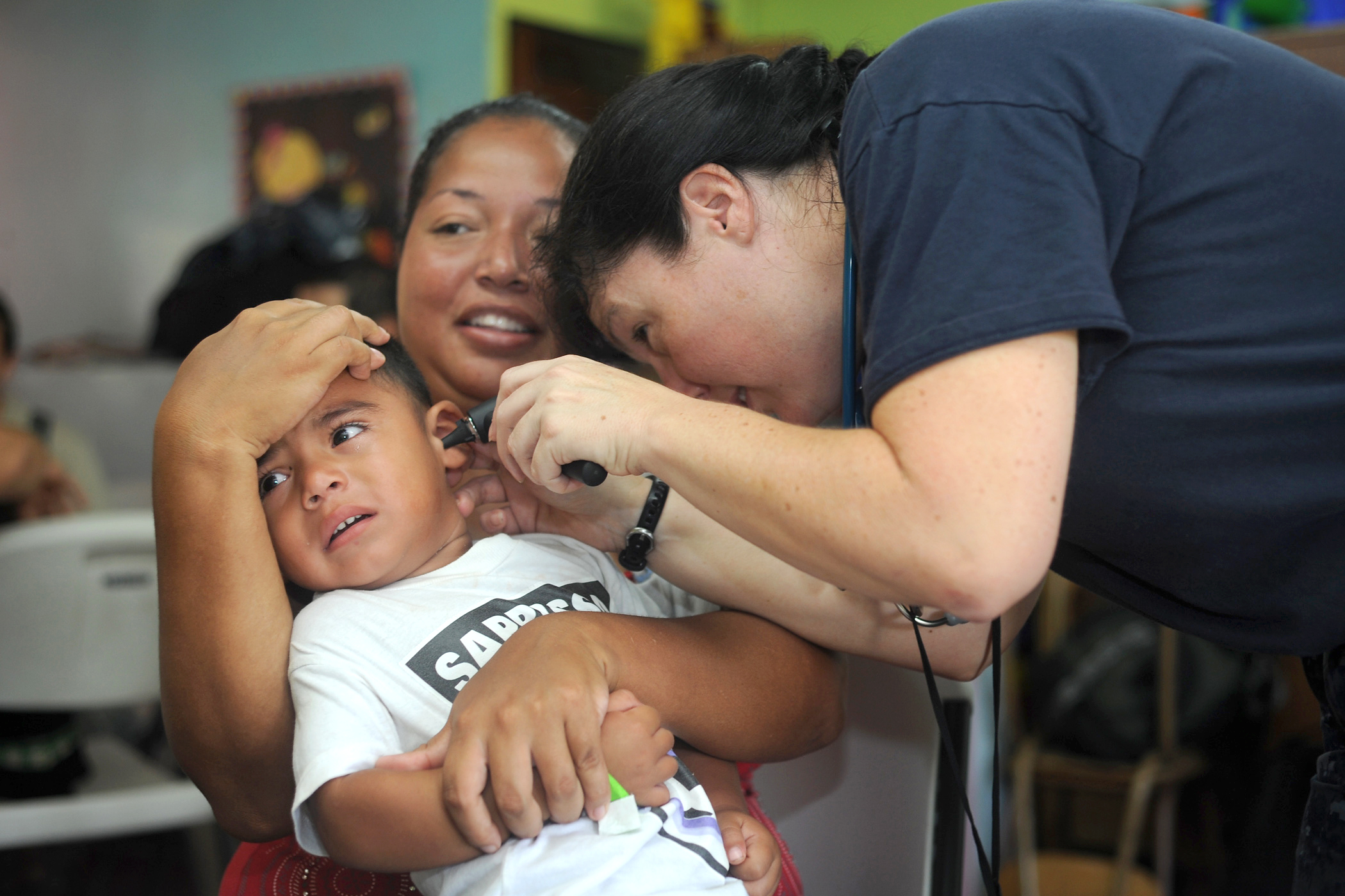 U.S. Navy Cmdr. Laurie Hale examines a patient at the Escuela Fray ...