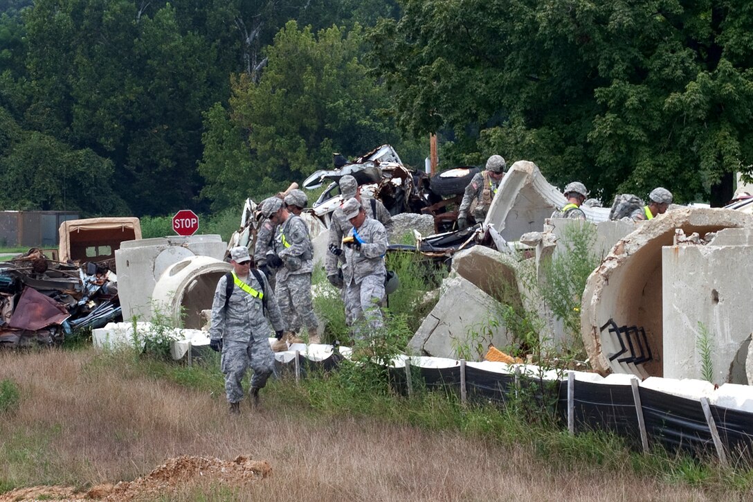 Soldiers and airmen search for casualties before clearing debris from a ...