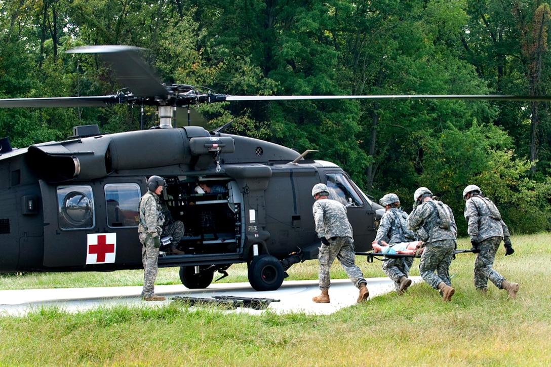 Army medics load a mock victim into a UH-60 Black Hawk medevac ...