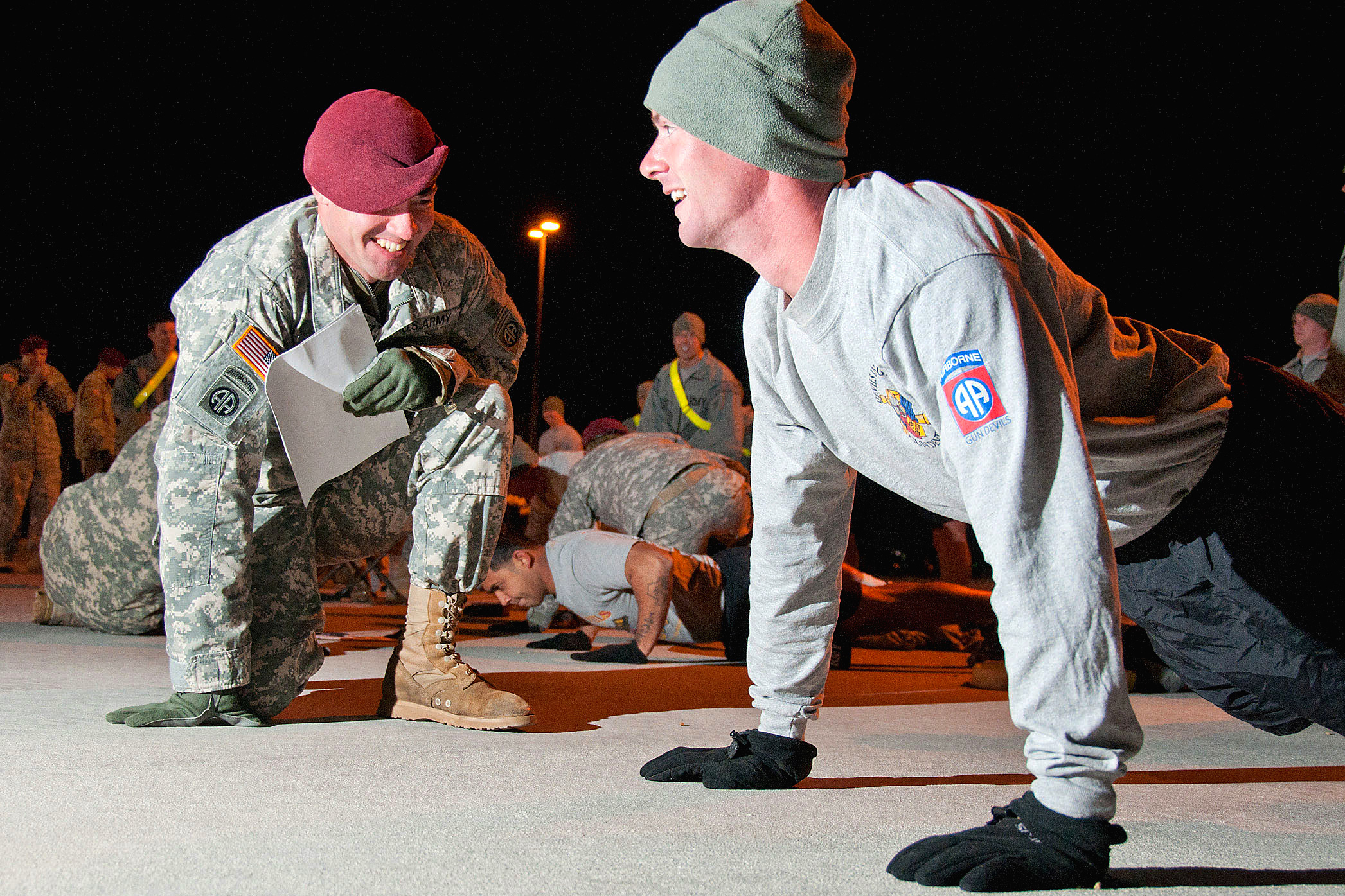 Army Staff Sgt. James Lipscomb, left, grades a paratrooper's pushups ...