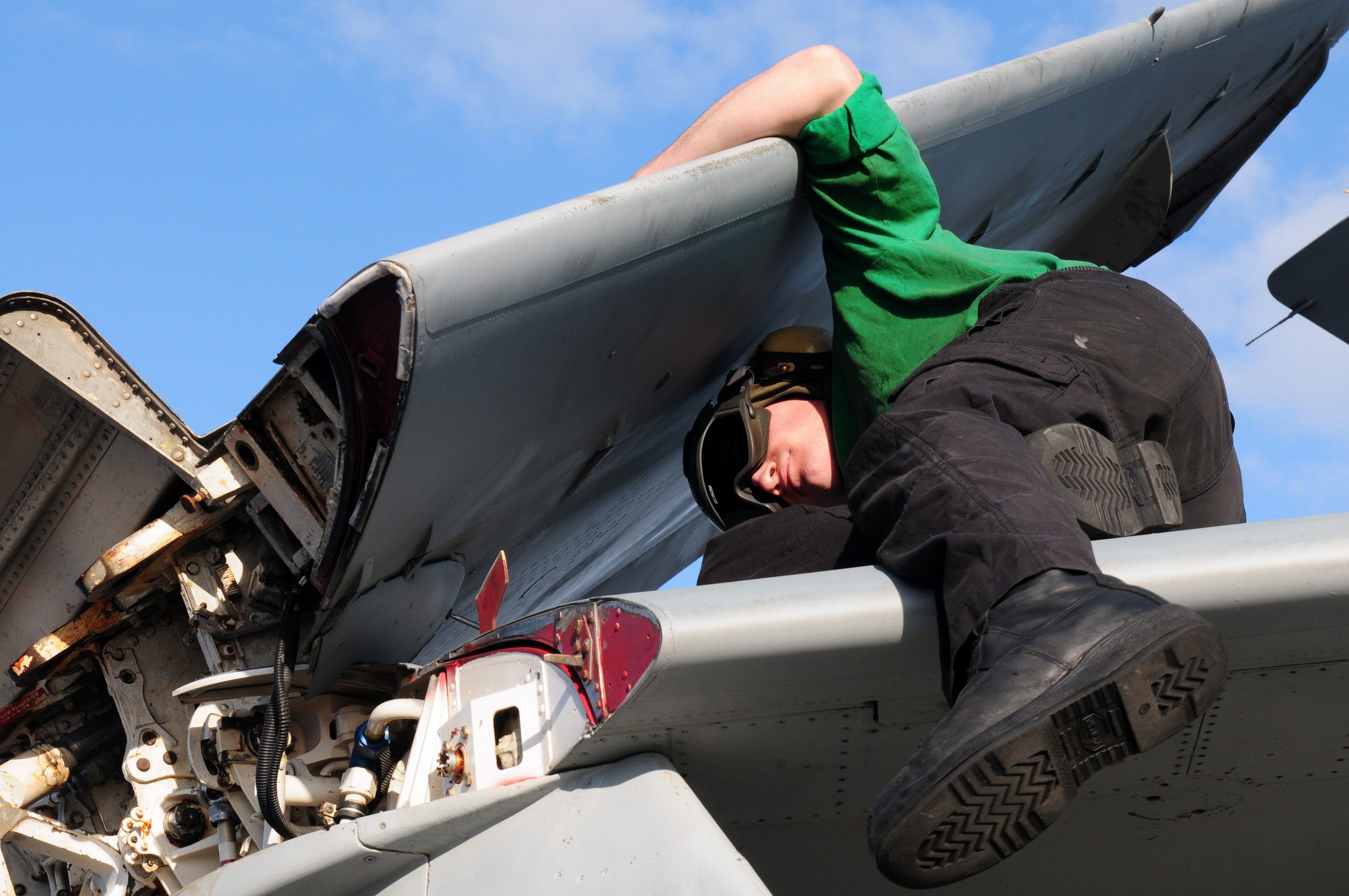 U.S. Navy Petty Officer 3rd Class Robert Liles performs maintenance on ...