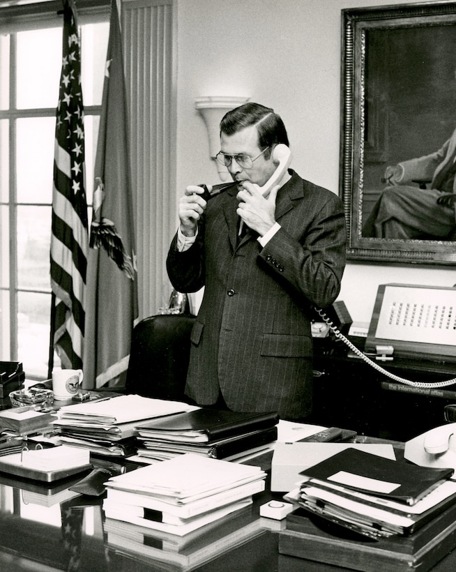 Defense Secretary Donald H. Rumsfeld speaks on the phone, smoking his ...