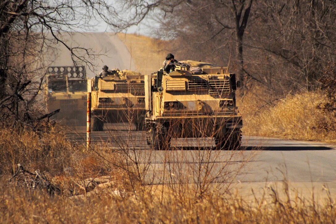 A convoy carrying U.S. Army multiple launch rocket systems drives ...