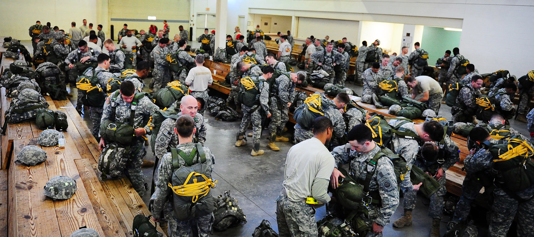 U.S. Army paratroopers perform safety checks on their parachute ...