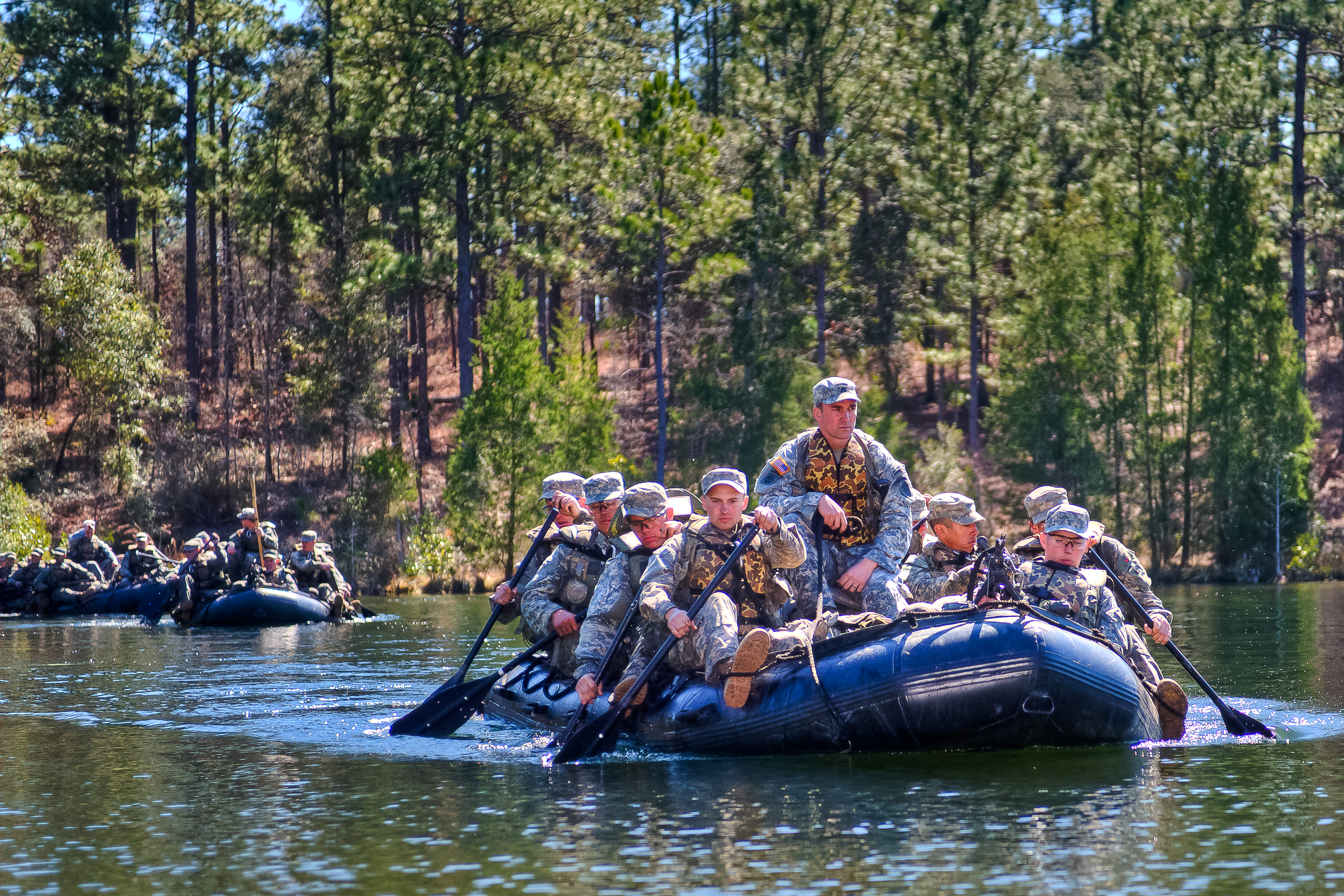 U.S. Army Ranger students paddle in rubber boats across a lake during ...