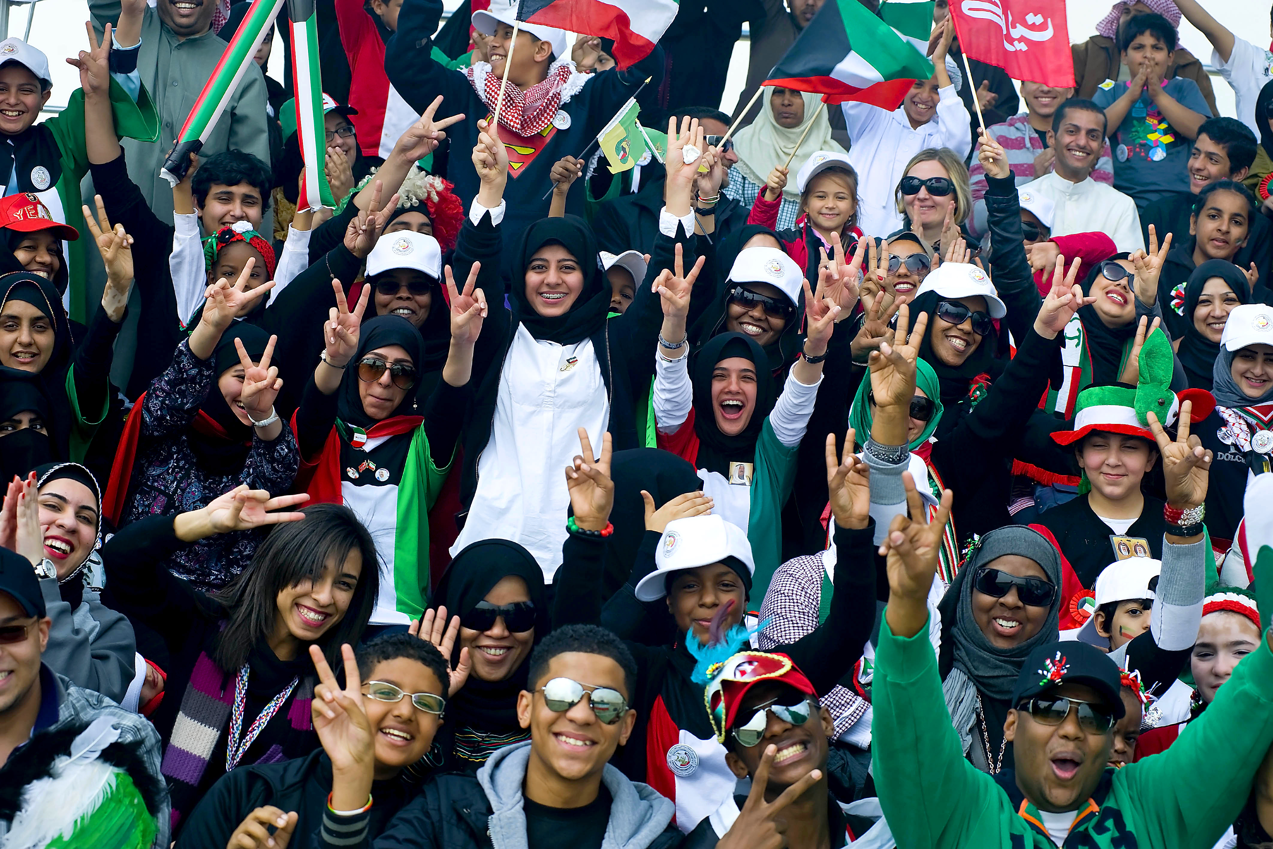 A crowd of Kuwaiti spectators erupt in cheers bearing a message of ...