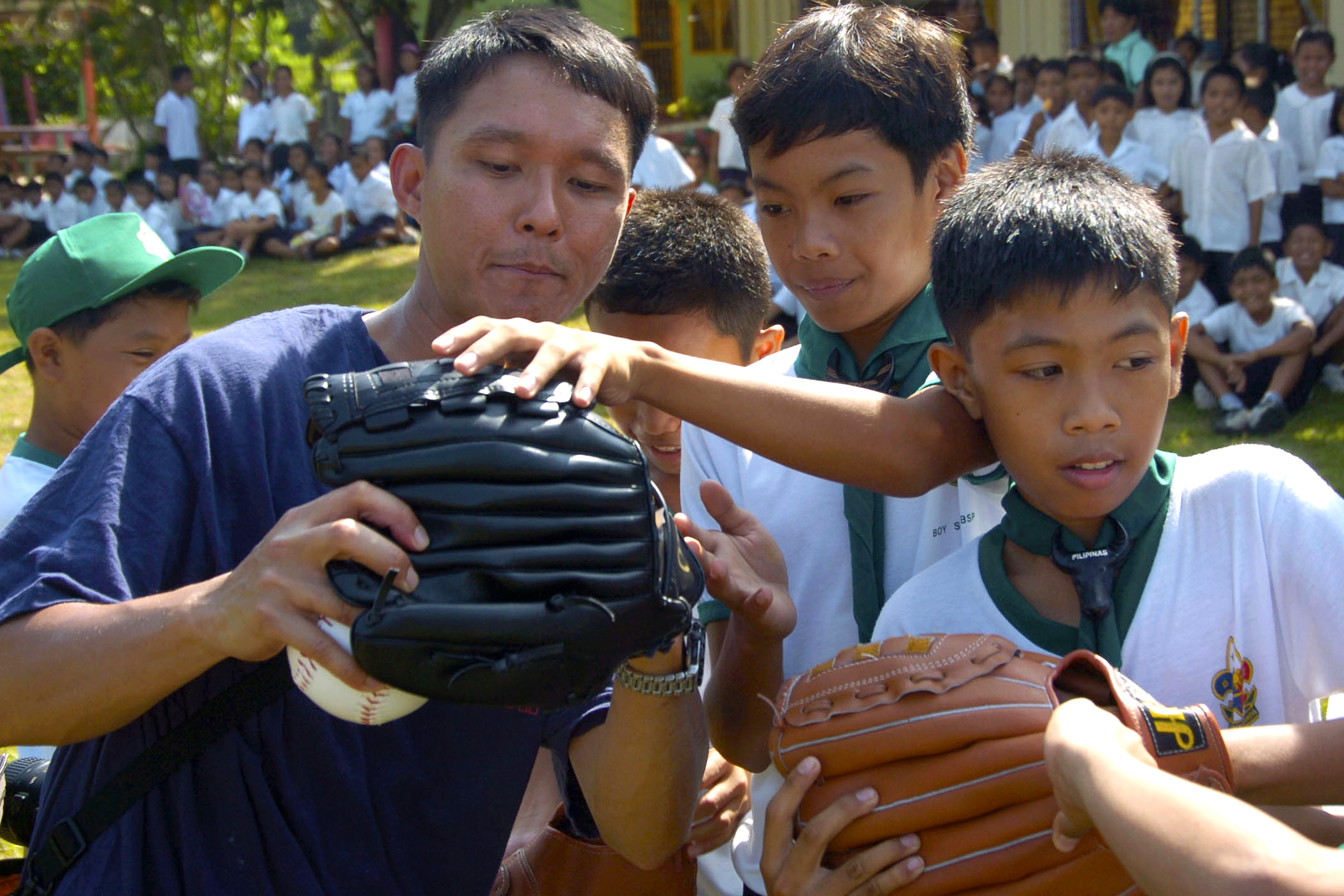 U.S. Navy Seaman Arbie Millanes shows a Filipino boy scout how to use a ...