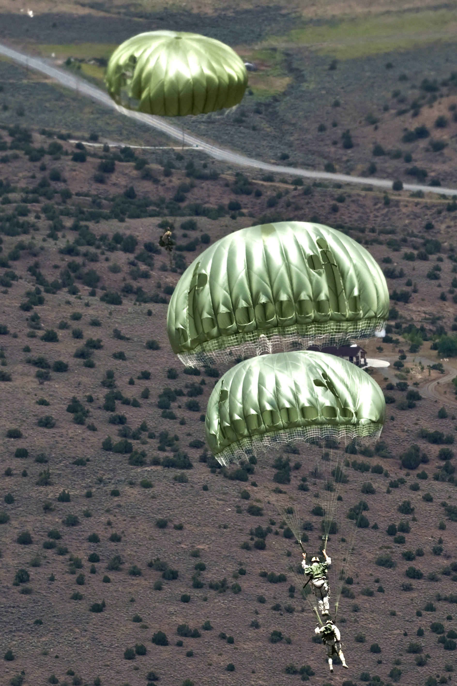 U.S. Air Force airmen drop into a landing zone over the Senator Harry ...