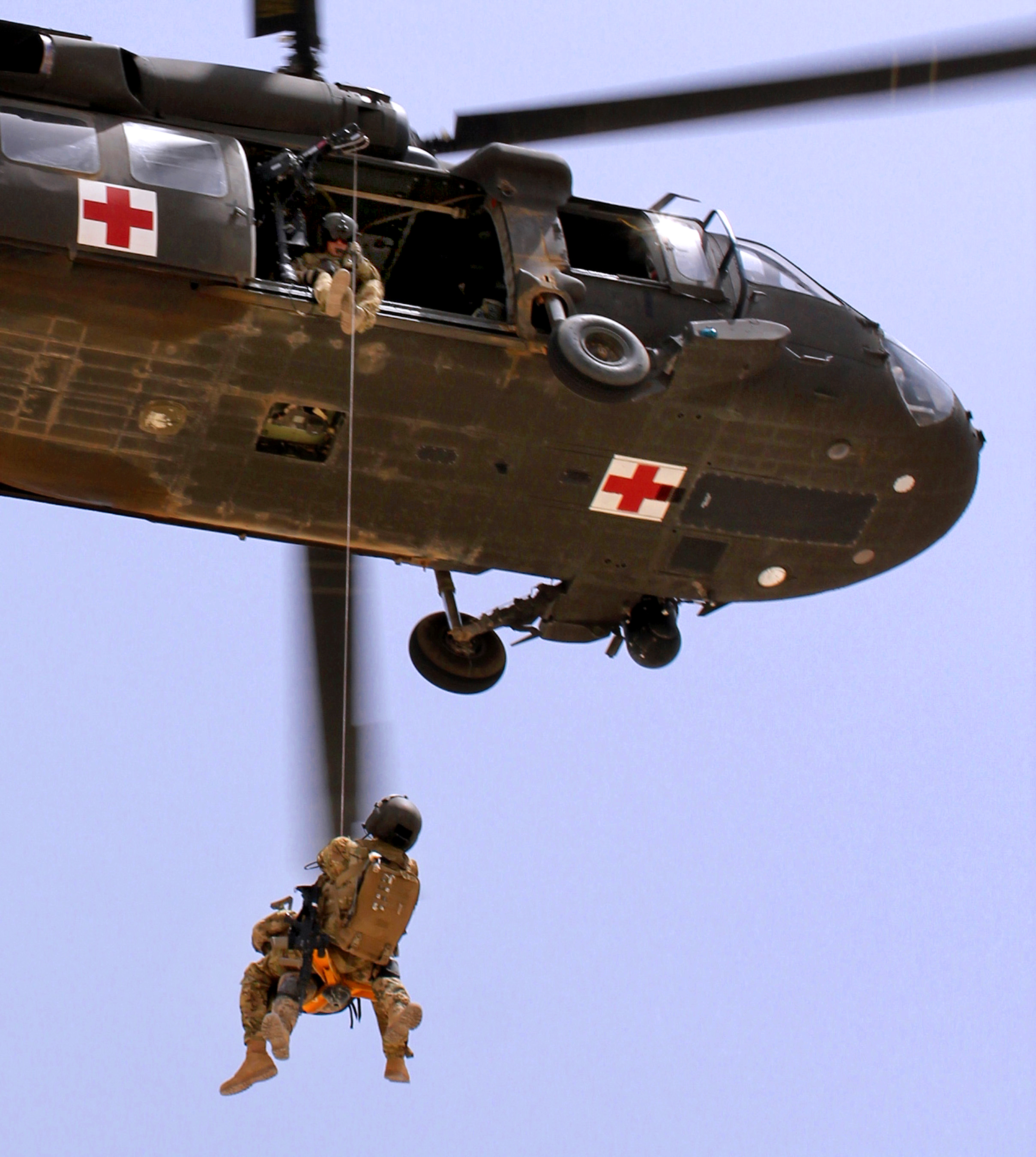 U.S. Army Staff Sgt. Travis Brown and a German soldier are lowered to ...