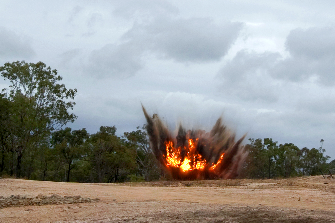 A cratering charge is denotated in a field after being placed by U.S ...