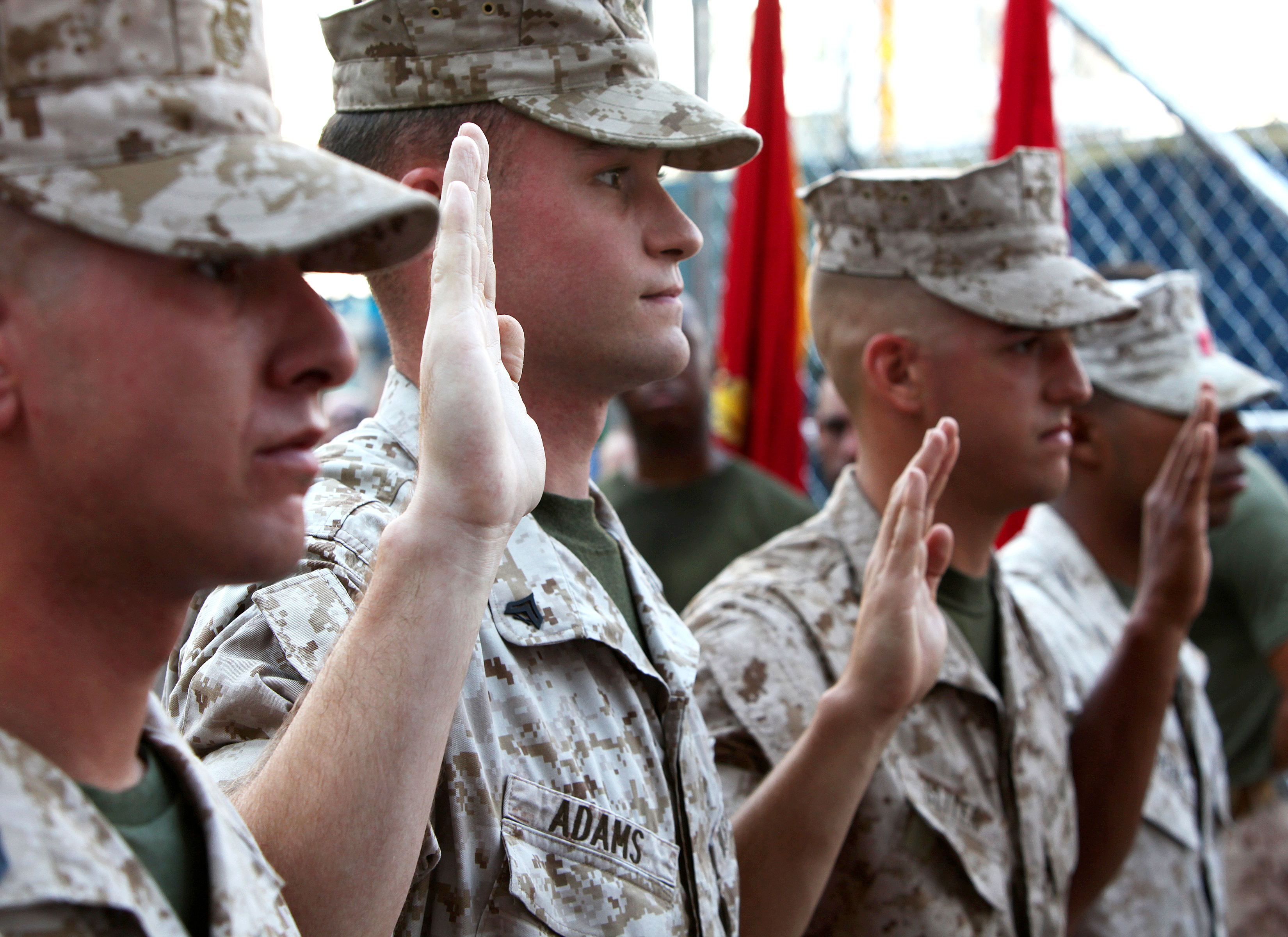 U.S. Marine Corps Cpl. Blake Adams, center, raises his right hand ...