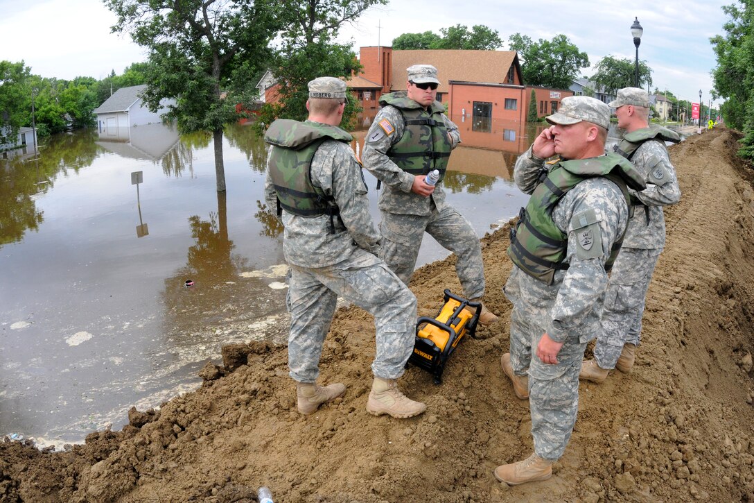 Army soldiers monitor flood water along a flood levee in Minot, N.D ...