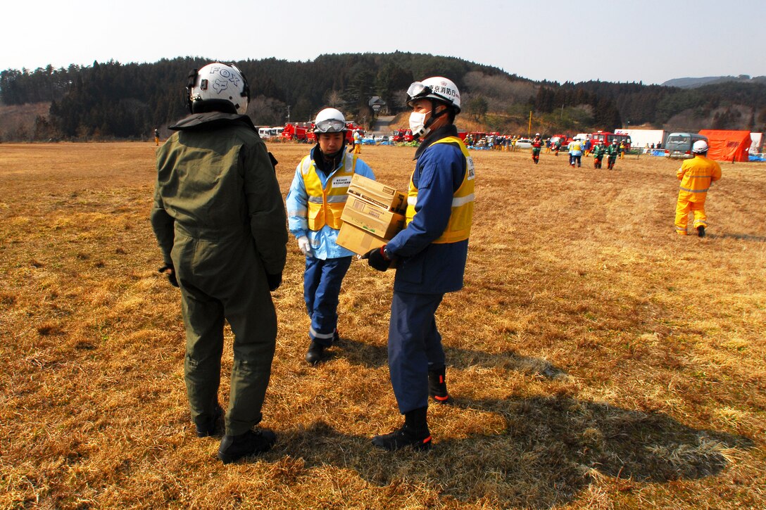Japanese aid workers accept humanitarian relief supplies from U.S. Navy ...