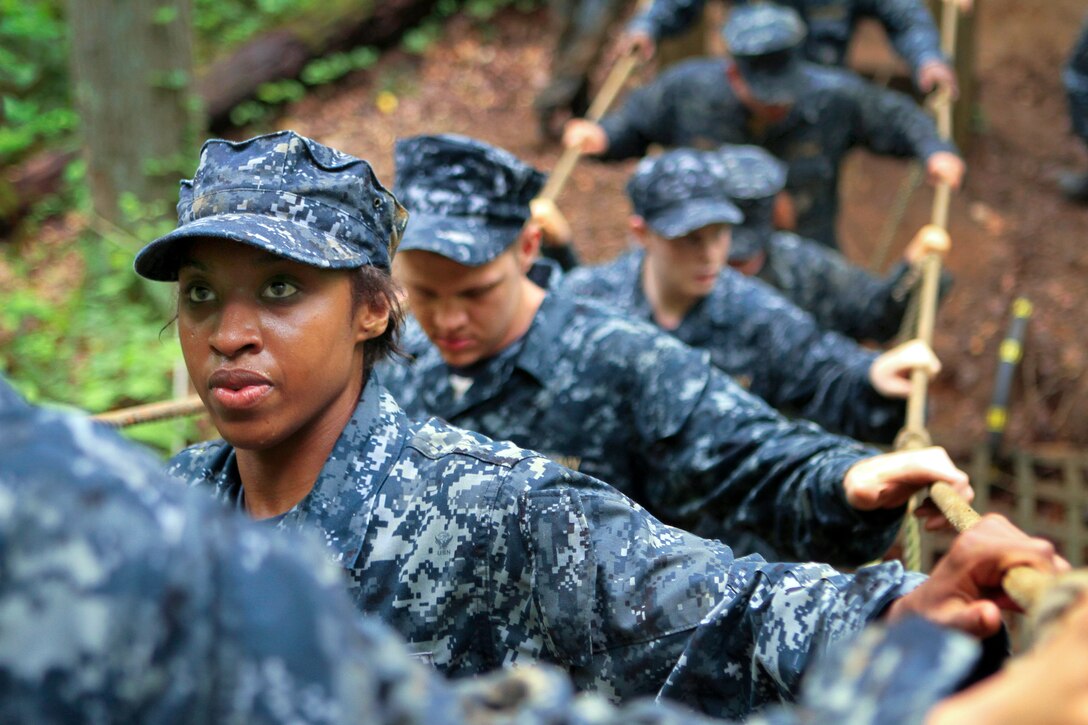 U.S. Naval Academy plebes navigate across a rope-bridge obstacle course ...