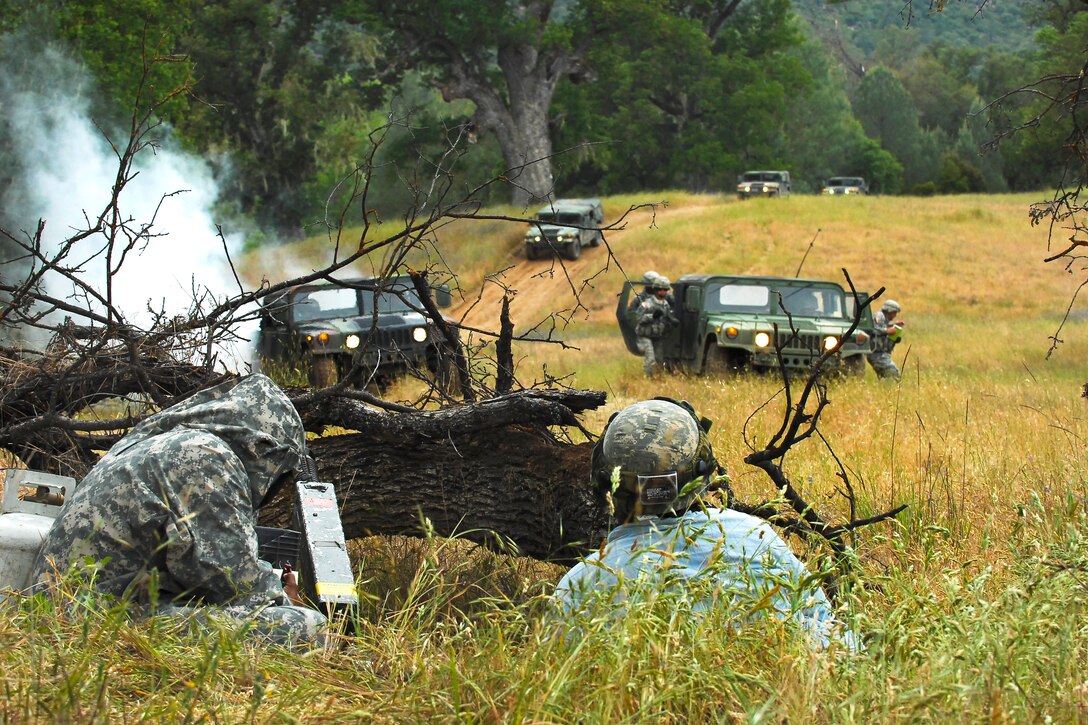 Army soldiers simulate an attack on an approaching convoy while playing ...