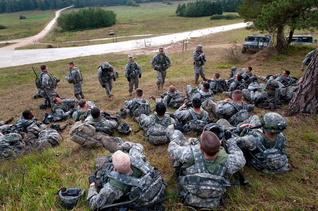 U.S. Army observer-controllers discuss a completed training scenario ...