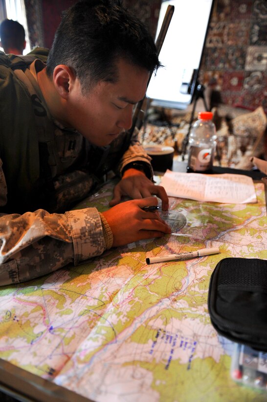 U.S. Army Capt. David Shin plots his unit's positions on a map during ...