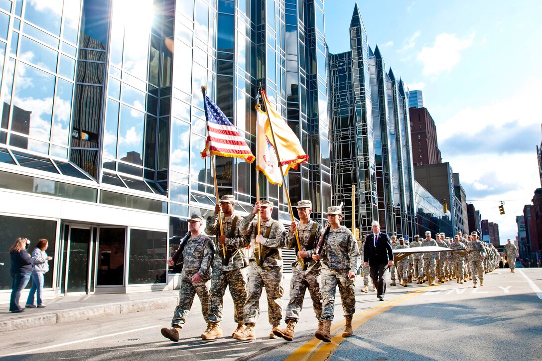 The Army Color Guard leads the way as Army Reserve soldiers march ...