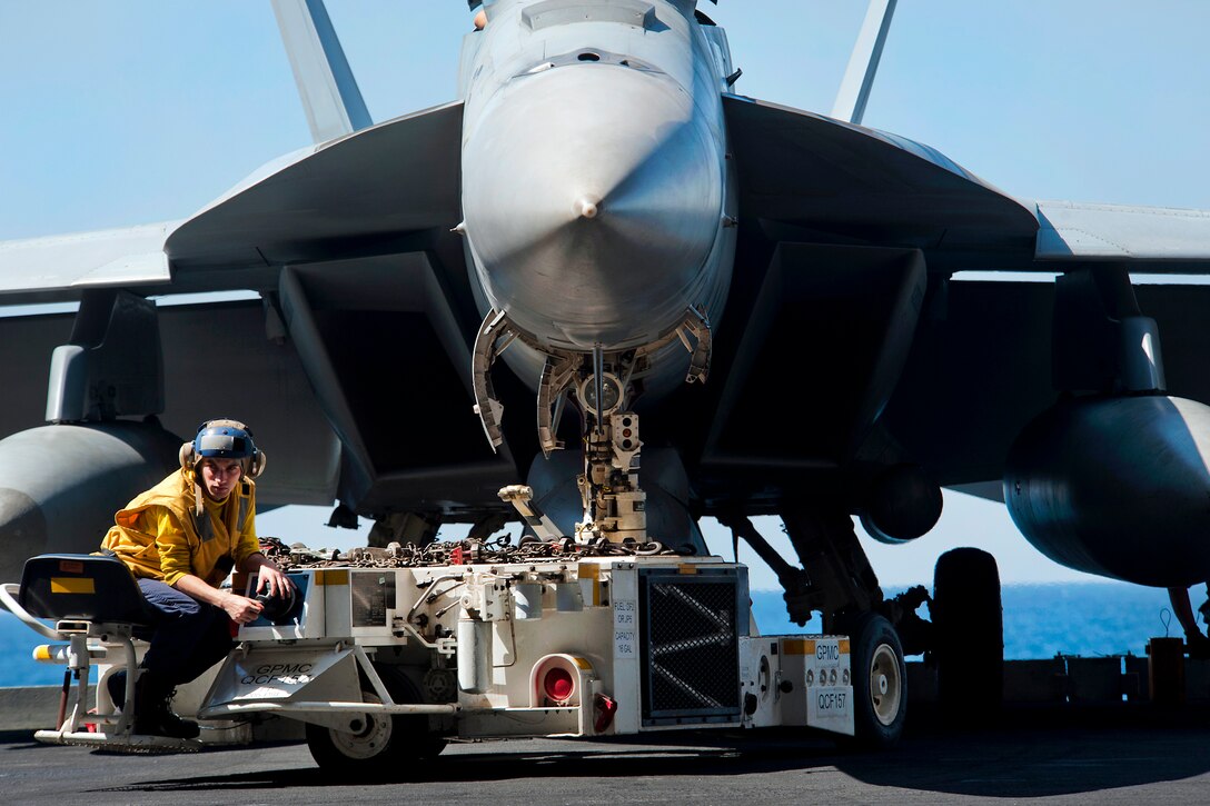 U.S. Navy Petty Officer 3rd Class Marc Trietch maneuvers an F/A-18F Super Hornet with a spotting ...