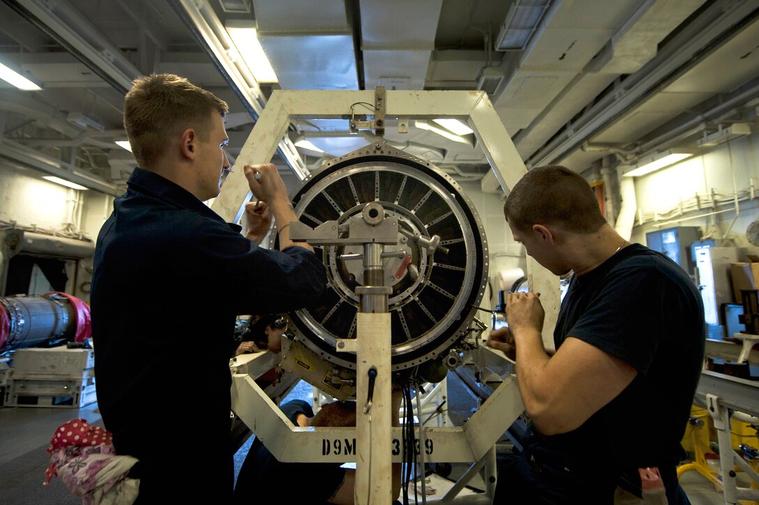 U.S. seamen Jason Nitz and Stefhan Spaulding tighten screws on the ...