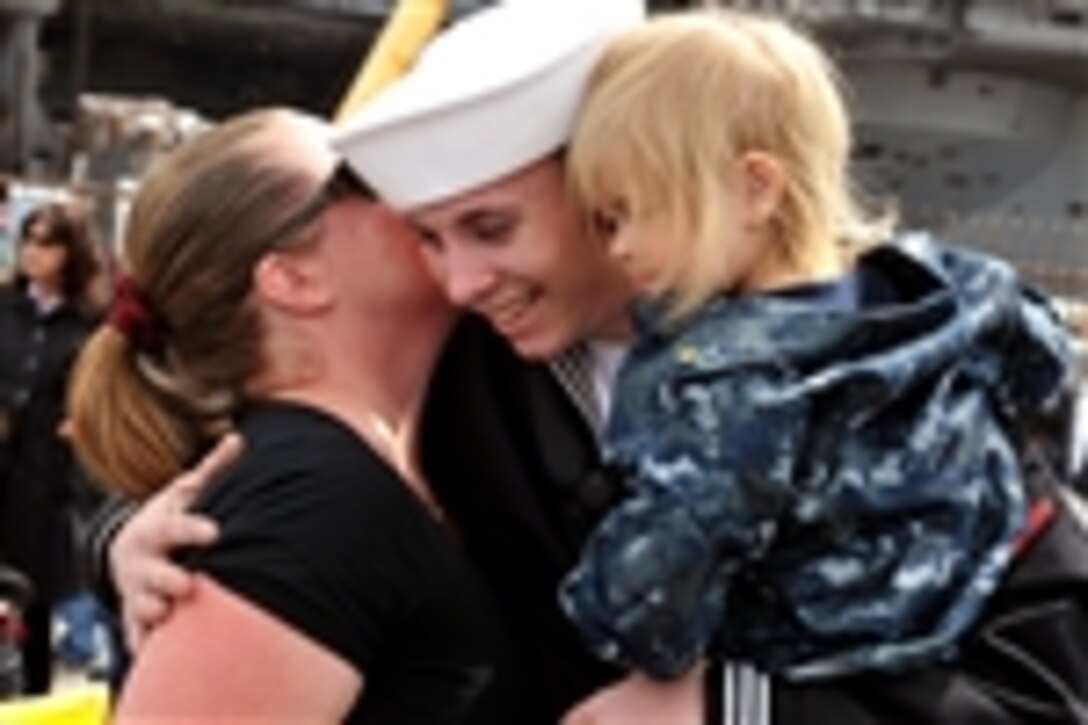 U.S. Navy Petty Officer 3rd Class Jared Moon embraces his family upon ...