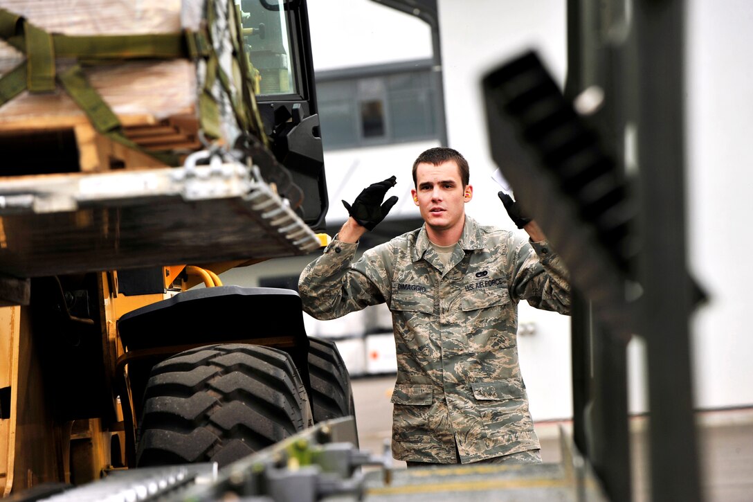 U.S. Air Force Senior Airman Kevin Dimaggio directs a pallet of ...