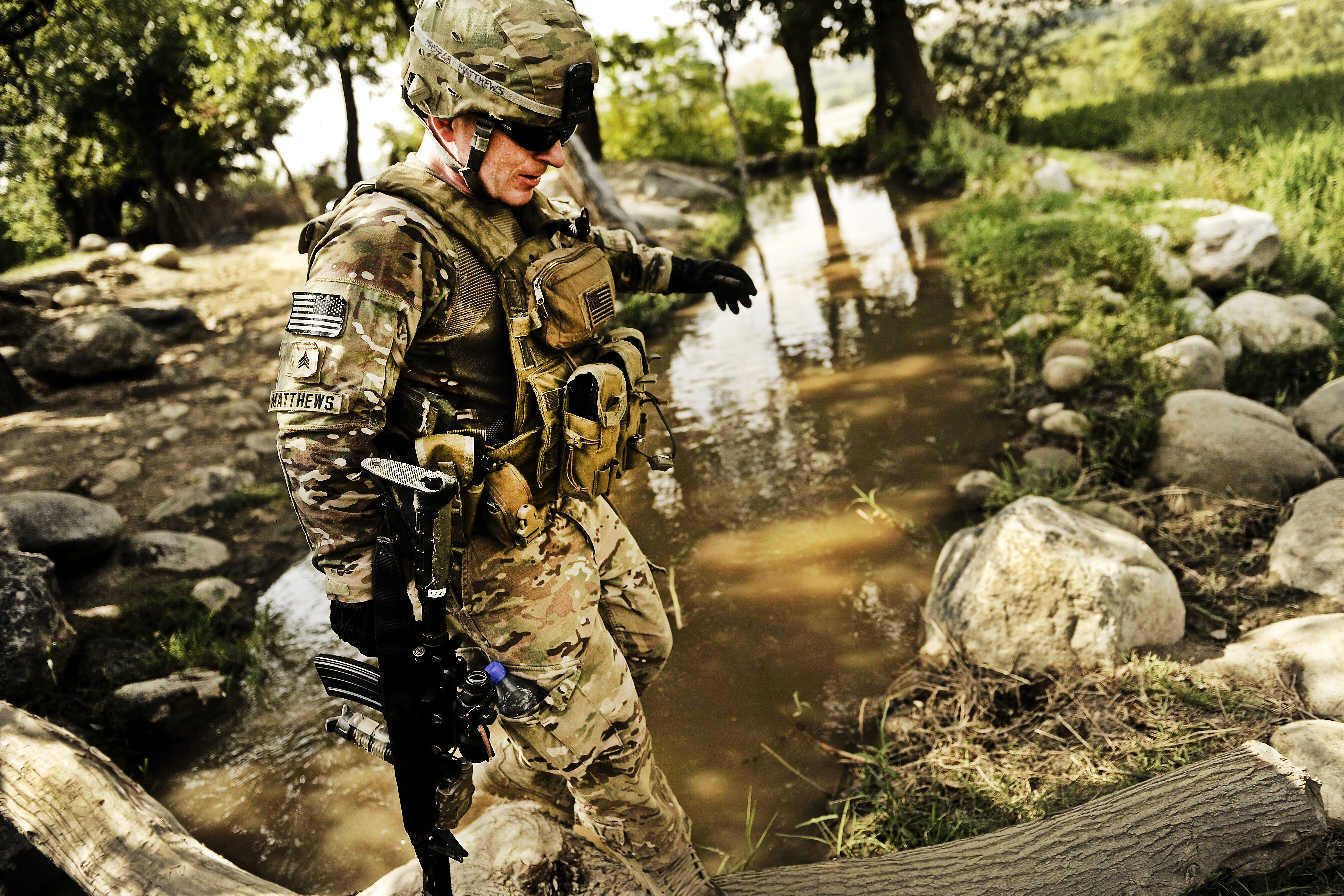 U.S. Army Sgt. Sean Matthews makes his way across a narrow log over a ...
