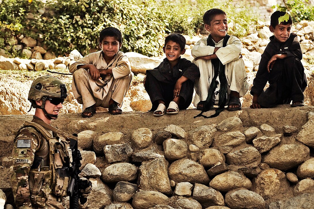 U.S. Army Spc. Kyle Graves talks with children while on patrol in the ...