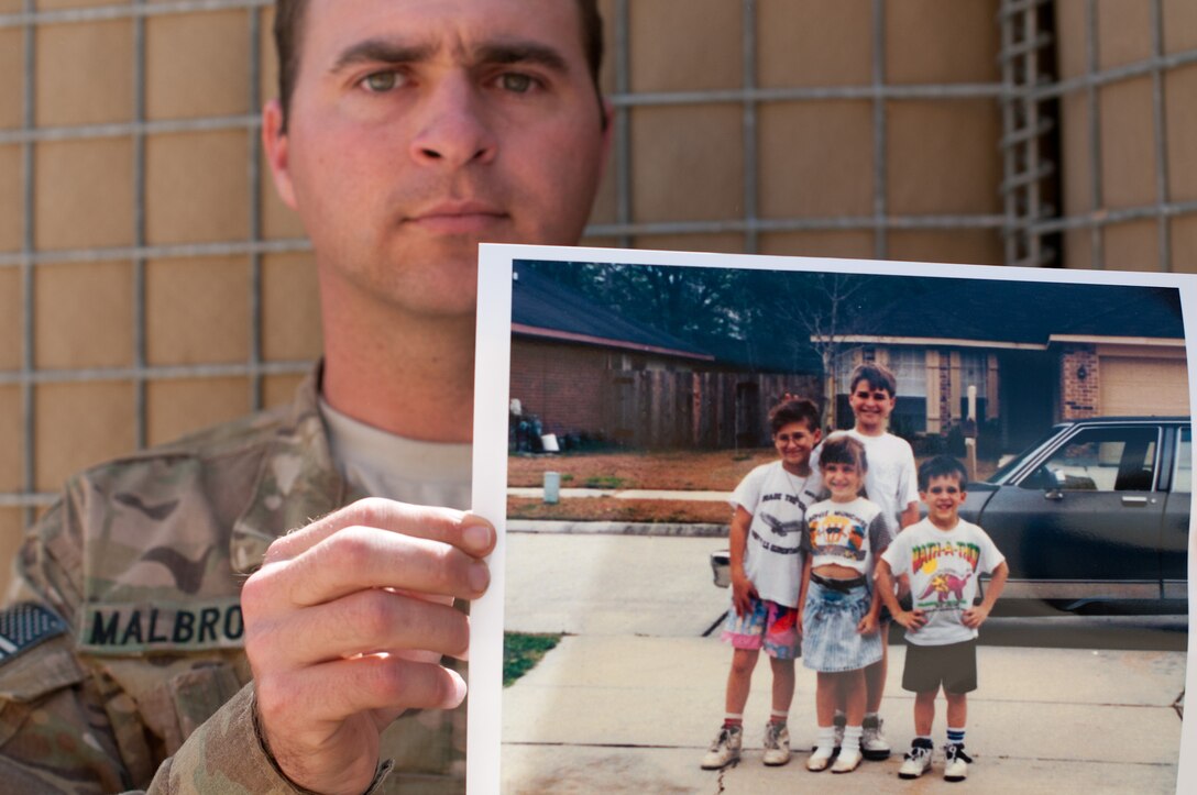 Army Warrant Officer Weldon Malbrough Jr. shows a family photo with ...