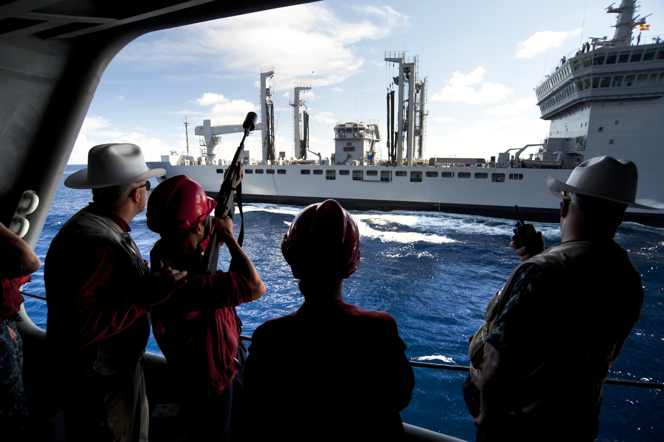 U.S. Navy Lt. Brian Hellmann, left, supervises as Seaman Binh Chu fires ...