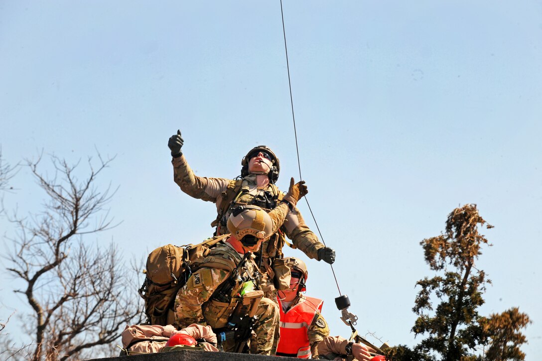 Air Force pararescue jumpers and air crew members prepare the line to ...