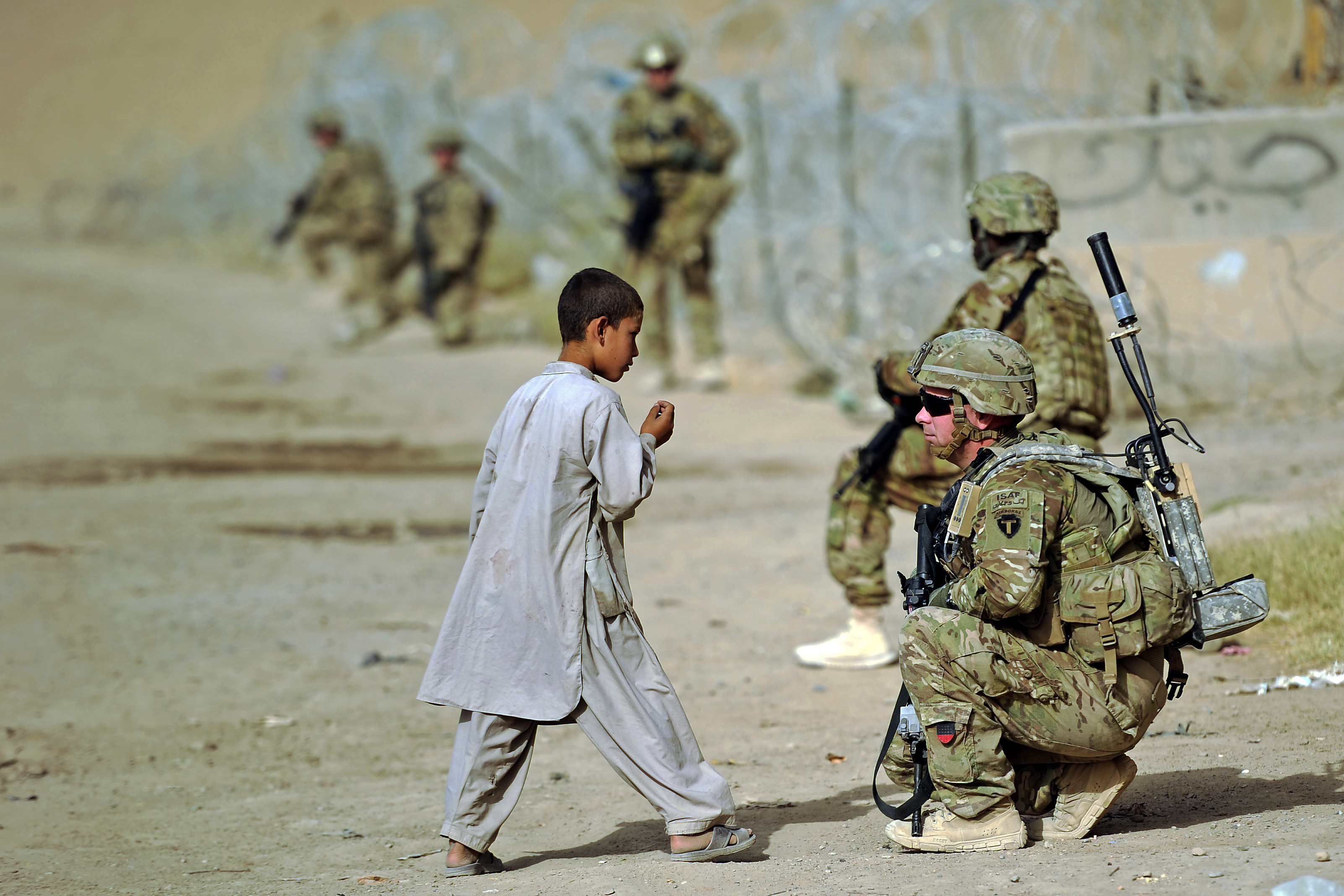 U.S. Army Sgt. Brian Reid talks with an Afghan child during a ...