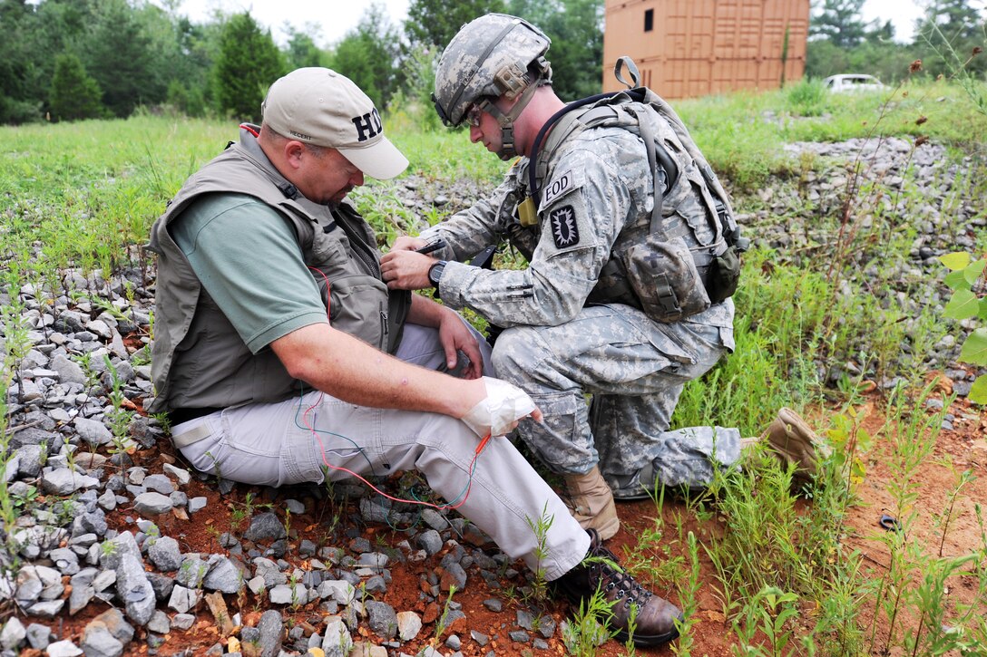 Army Staff Sgt. Tyler Peltier, right, removes simulated explosives from ...