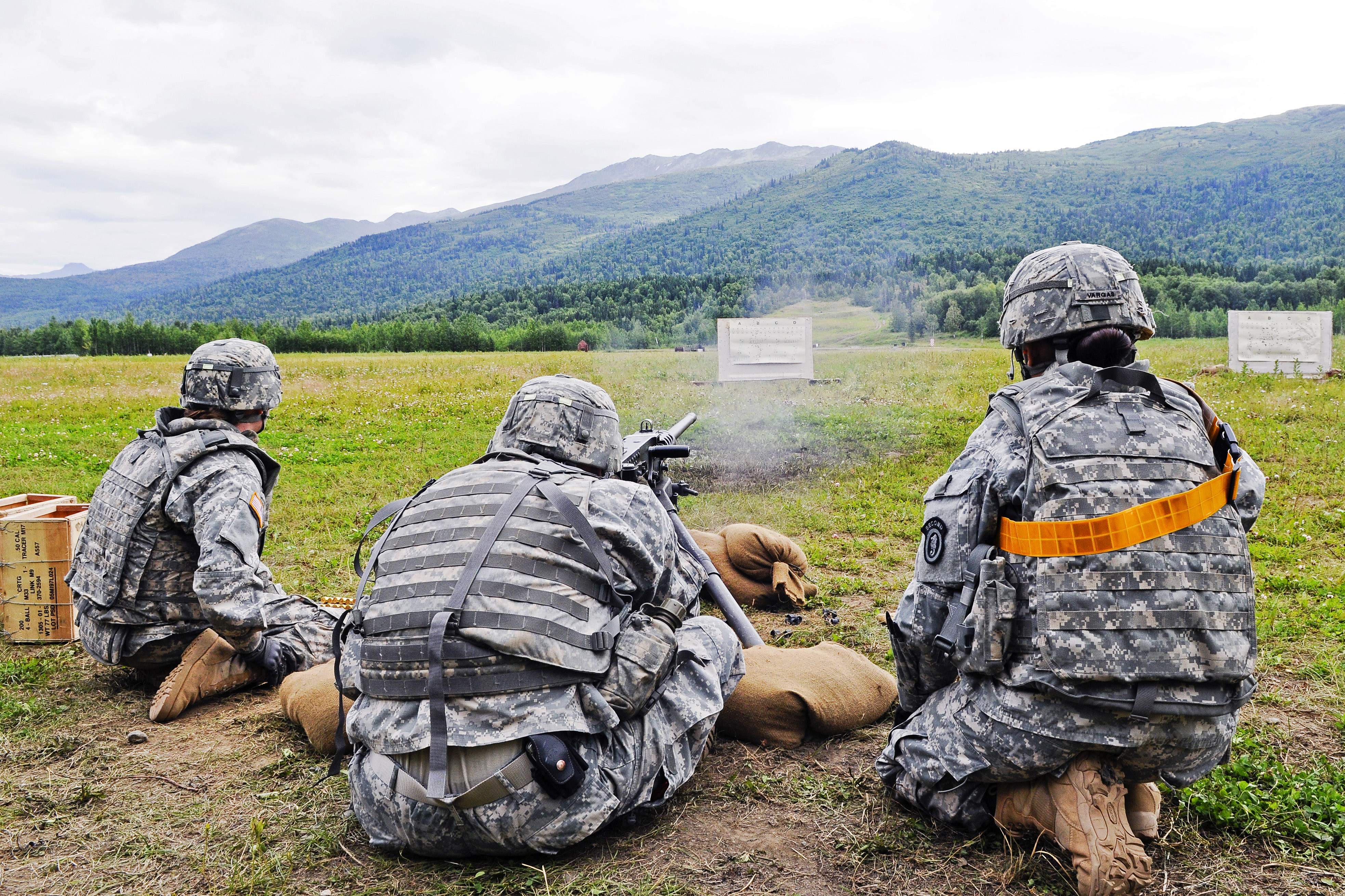 A soldier in the sitting position engages the 10-meter target with an ...