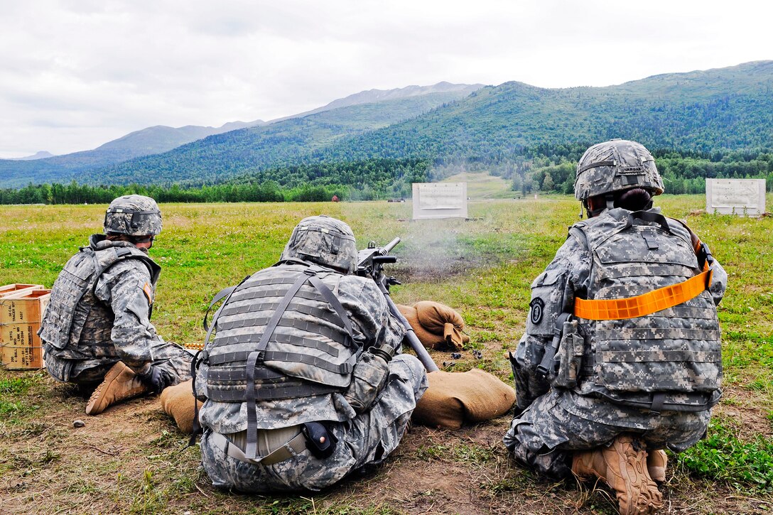 A soldier in the sitting position engages the 10-meter target with an ...
