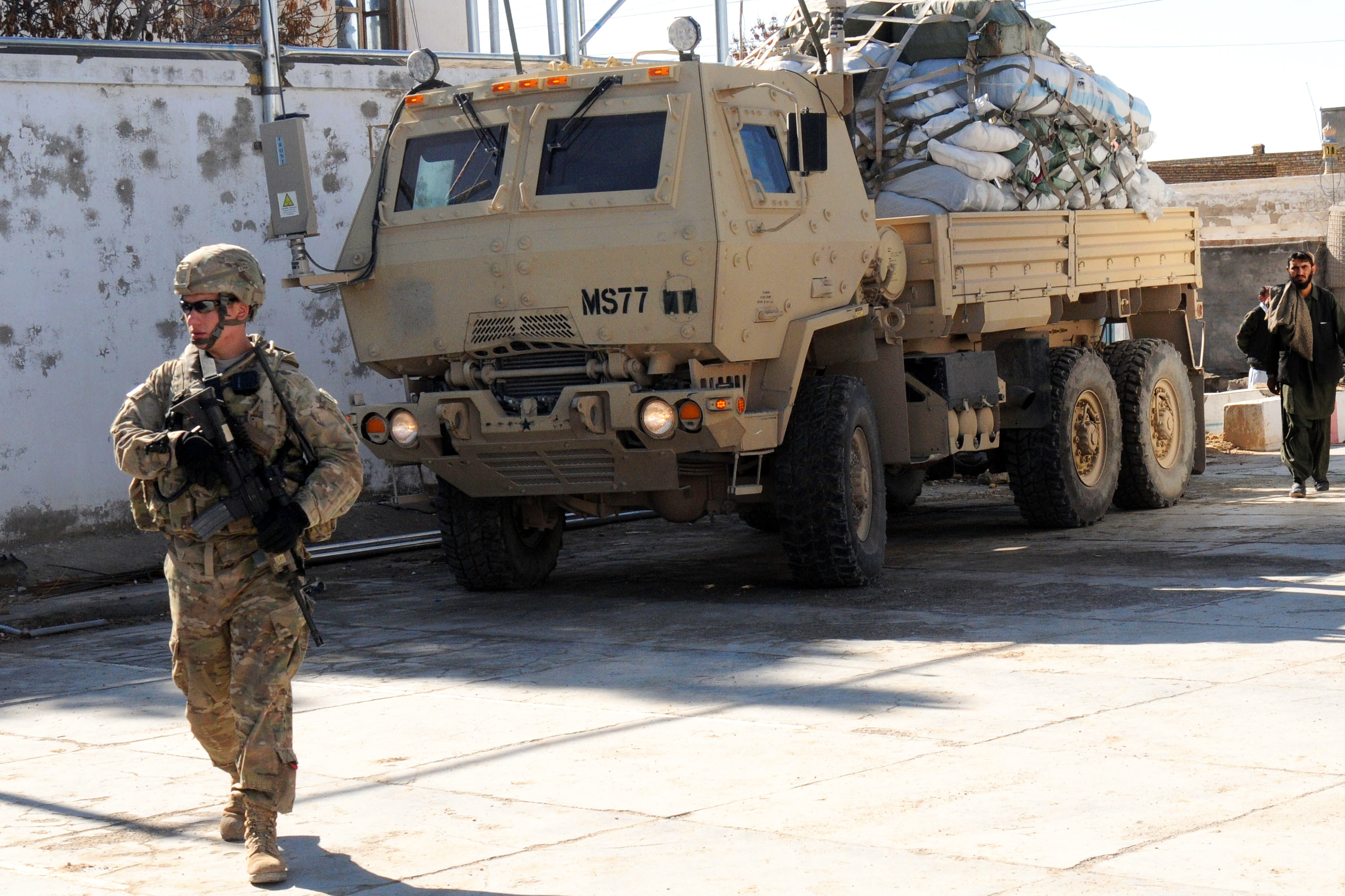U.S. Army Sgt. Paul Rothfeld ground guides a light medium tactical ...