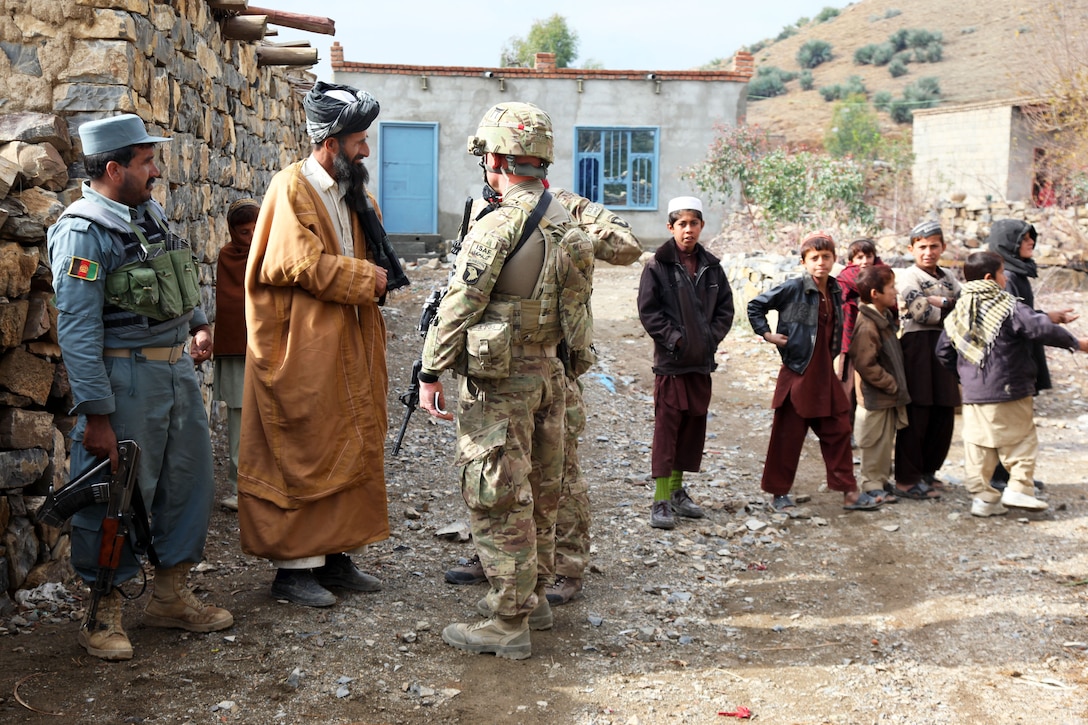 U.S. Army 1st Lt. Michael Tarasiewicz and an Afghan policeman speak ...