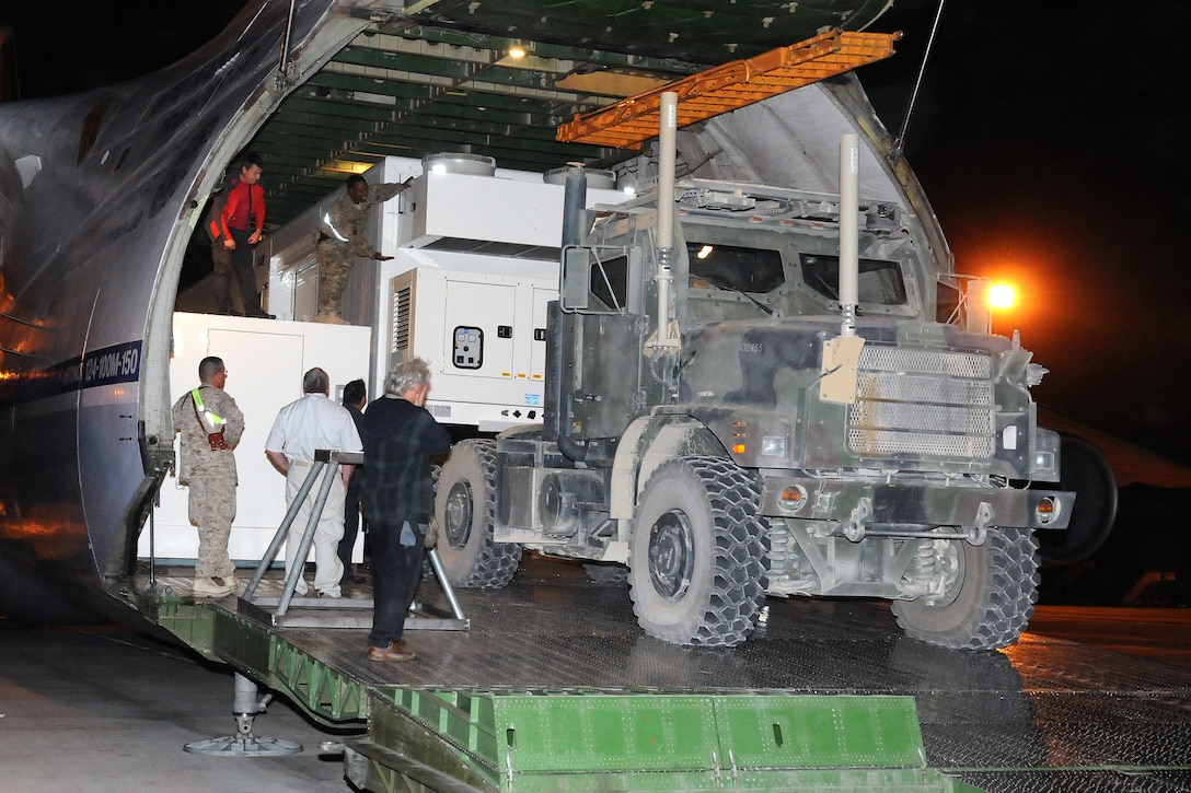 An AMK-31 vehicle drives off the ramp of an Antonov 124-100M aircraft ...