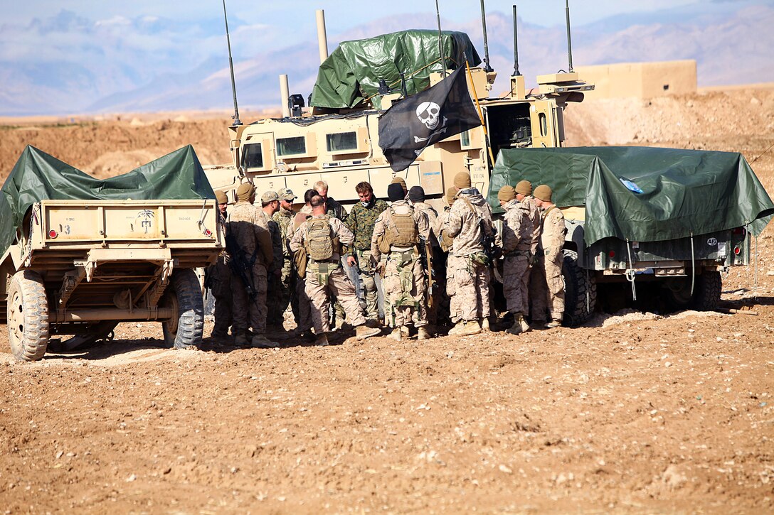 U.S. Marines huddle up for a briefing and receive orders during ...