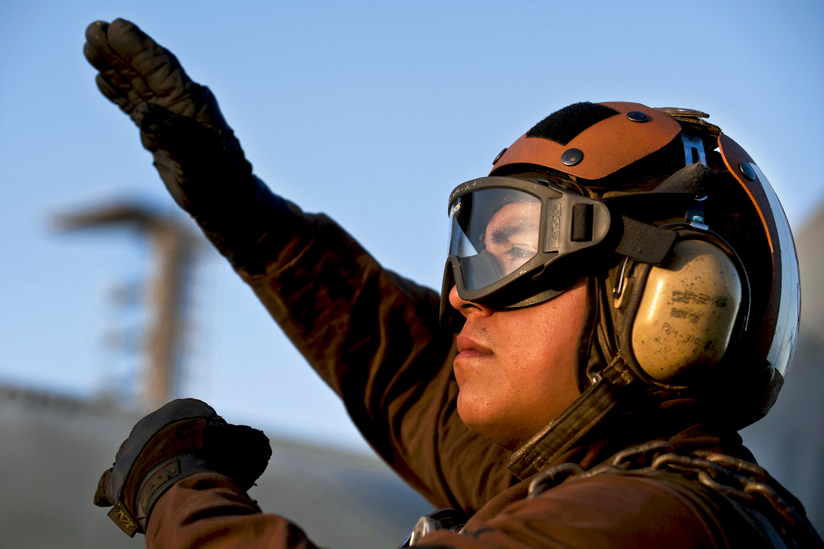 U.S. Navy Seaman Andres Molina-Valencia signals to a plane captain ...