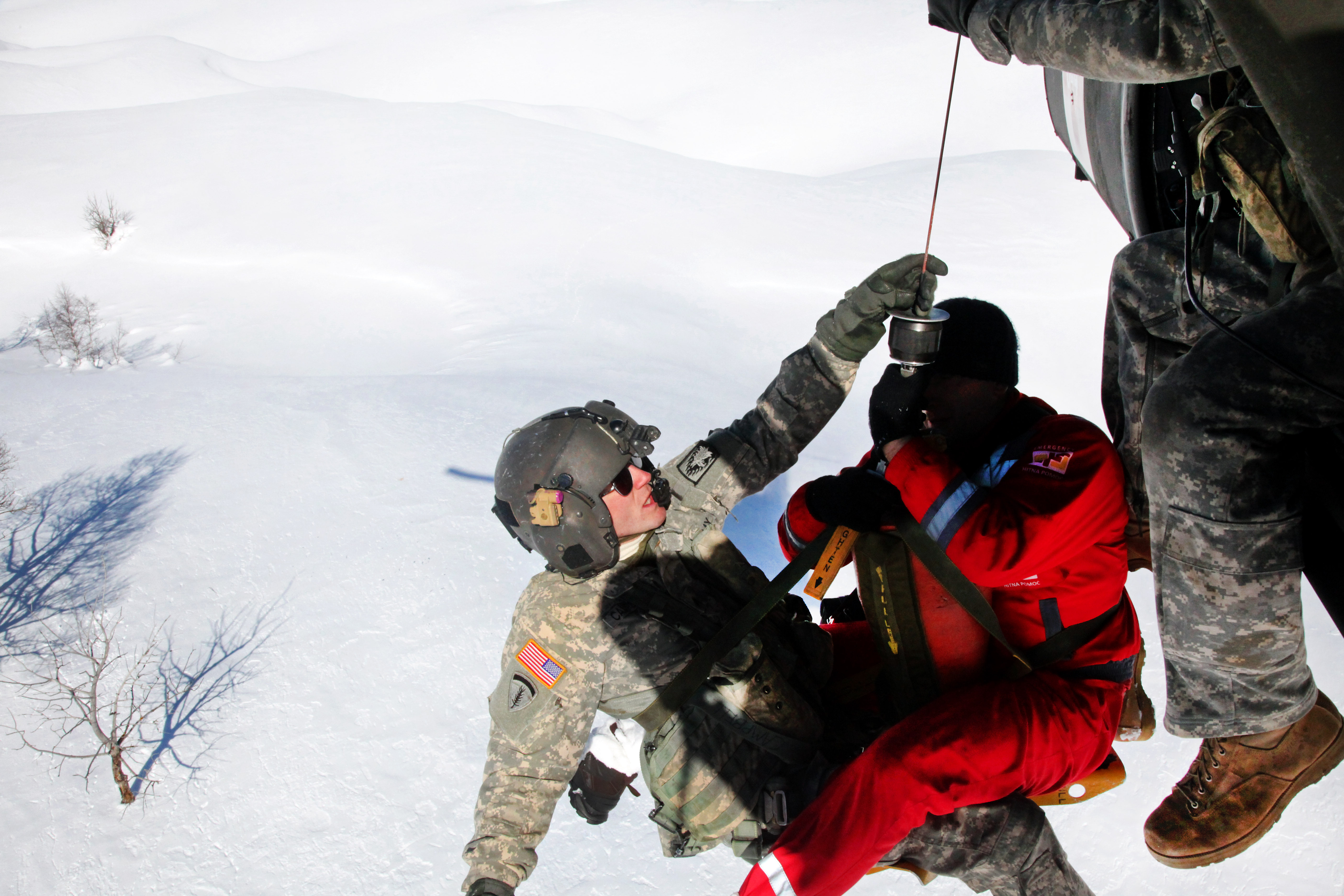 Crews hoist Dr. Darko Nisavic, center, and U.S. Army Sgt. Joseph ...