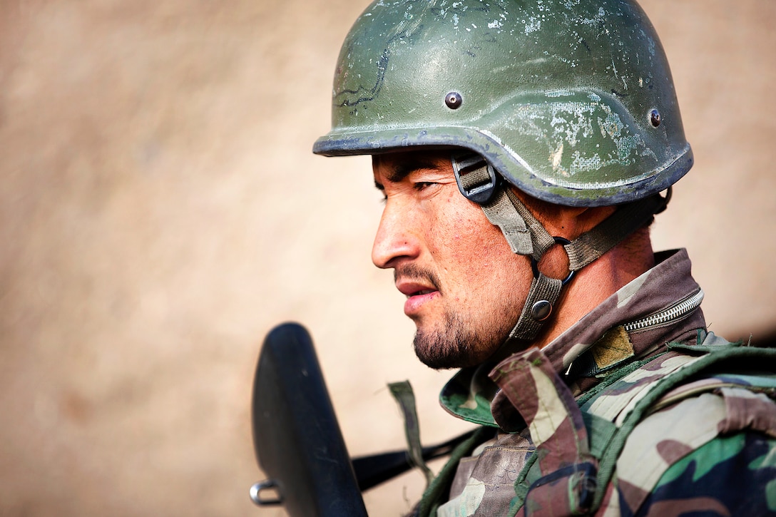 Afghan soldier Abdul Karim provides security while fellow soldiers and ...