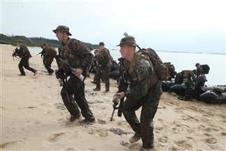 Marines run up the Kin Blue training area beach after leaving their ...