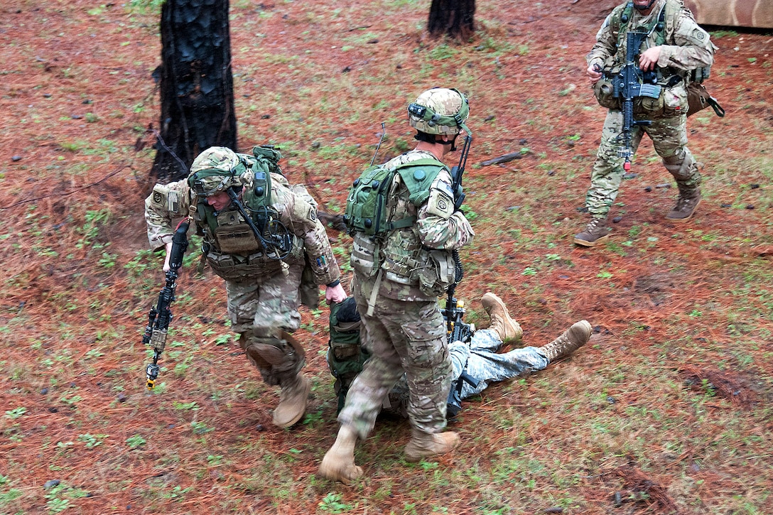 Paratroopers drag a mock wounded soldier during a simulated battle with Taliban insurgents in a ...