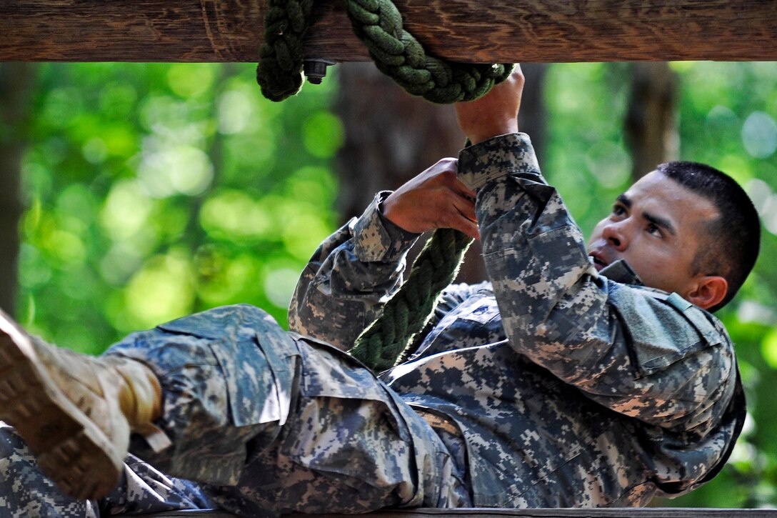 Army Staff Sgt. Victor Marquez-Rodriguez Sr. pulls himself up a wall ...